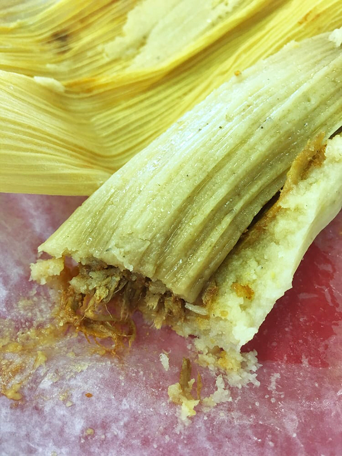 The cross-section of a perfect tamale reveals what centuries of culinary tradition looks like &ndash; tender masa embracing seasoned filling in a delicious hug.