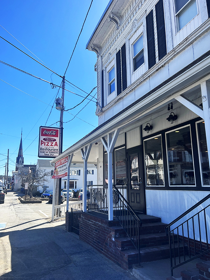 Tilton House of Pizza's classic New England exterior hides a red-checkered wonderland where pizza traditions remain gloriously unchanged.