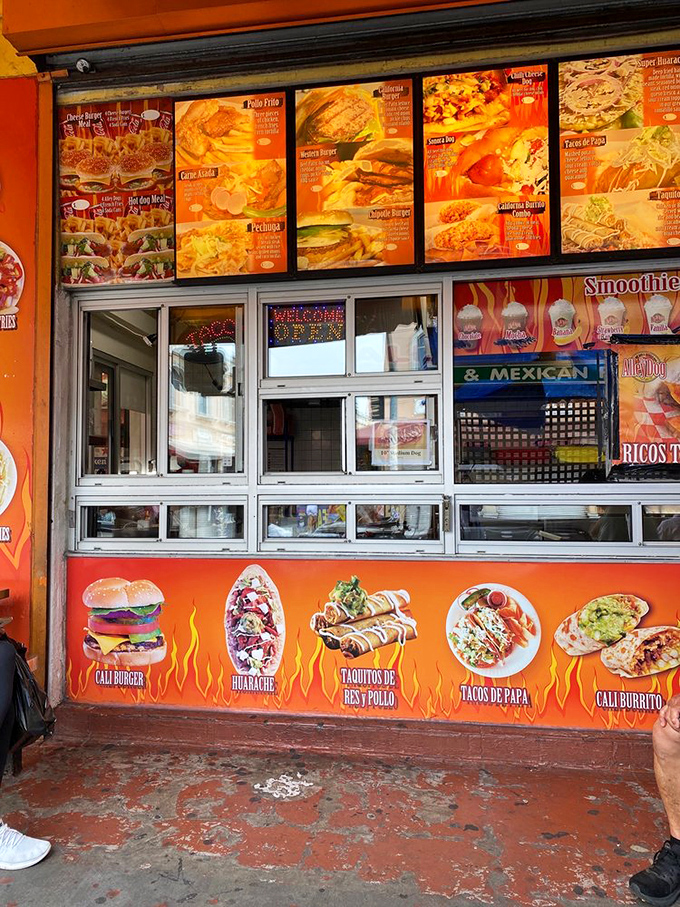 Colorful menu boards showcase a mouthwatering fusion of flavors that elevate the humble hot dog to sidewalk gourmet status.