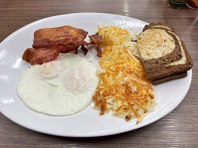 The holy trinity of breakfast: perfectly cooked eggs, bacon with ideal crisp-to-chew ratio, and hash browns that deserve their own fan club.