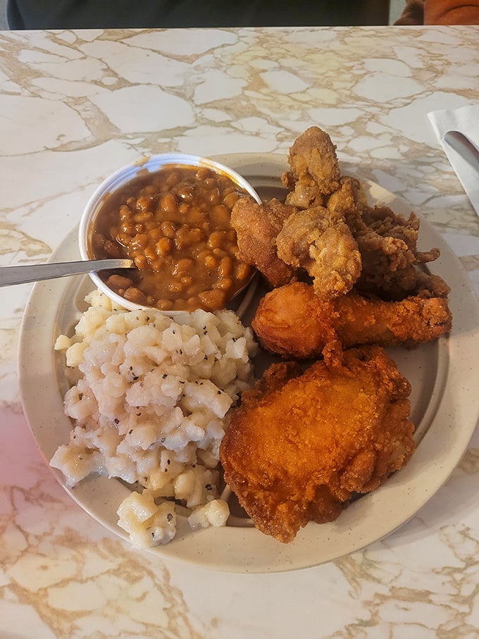 Comfort food nirvana: crispy fried chicken alongside creamy potato salad and baked beans that would make any grandmother nod in approval.