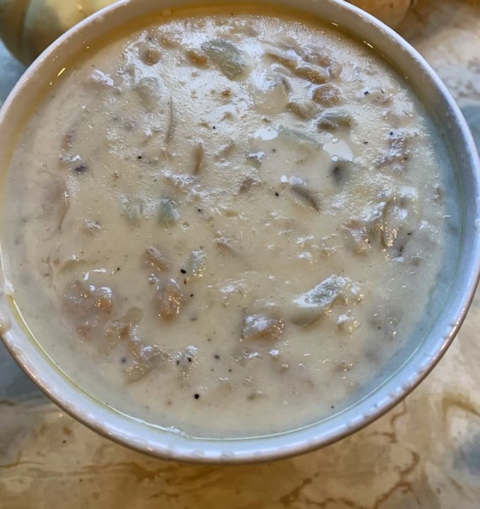Even in a humble green bowl, this chowder commands respect. The plastic spoon is merely a delivery system for what could be liquid gold.