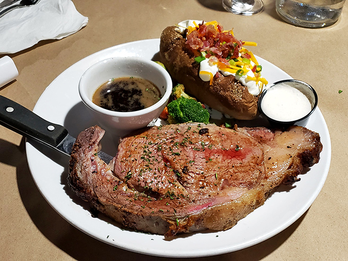 Behold the prime rib in its natural habitat &ndash; accompanied by a loaded baked potato that's dressed better than I am most days.