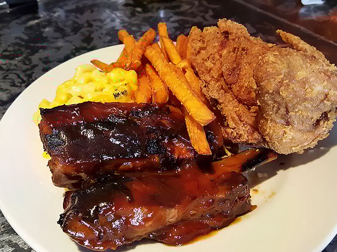 The holy trinity of comfort: sticky-sweet BBQ ribs, crispy fried chicken, and mac and cheese that could make a cardiologist reconsider their career choice.