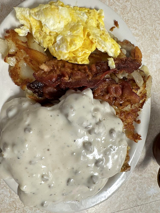 Behold the breakfast trinity: perfectly crisp bacon, eggs that actually know what "over easy" means, and country gravy that could make cardboard taste good.
