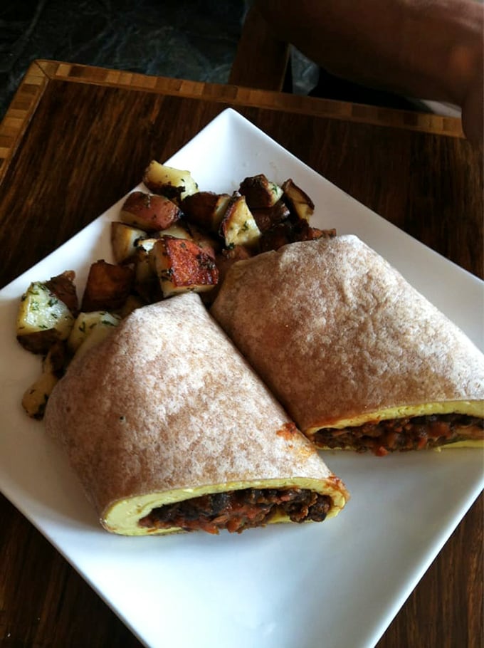 A breakfast burrito that demands to be photographed before eaten. Those crispy potatoes on the side aren't just garnish&mdash;they're supporting actors deserving of awards.