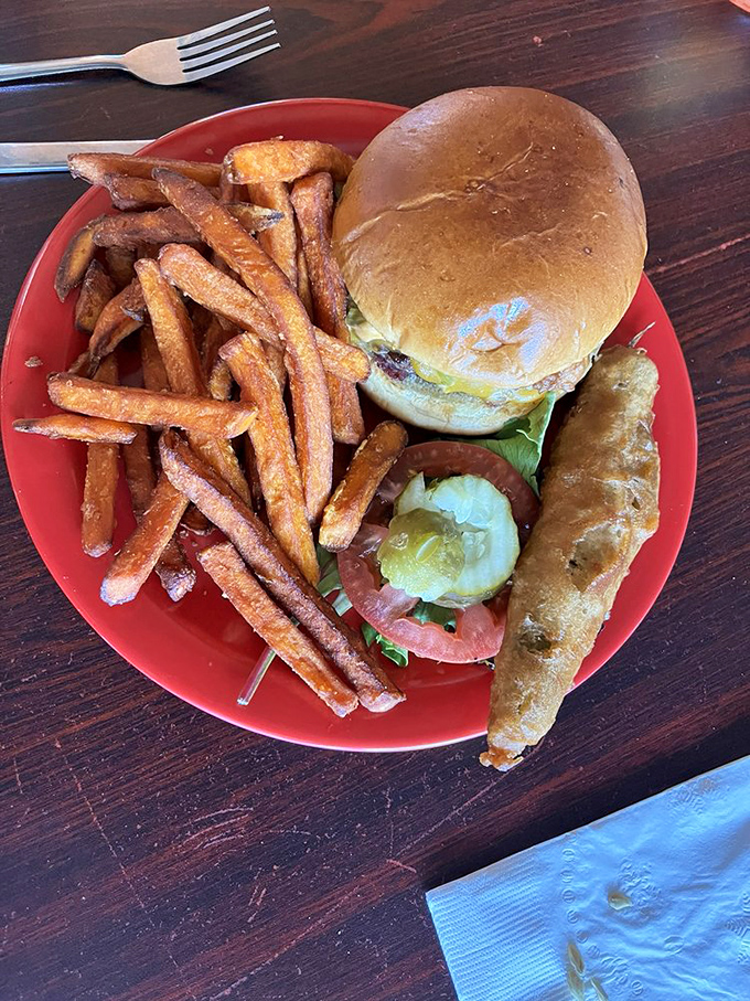 The holy trinity of burger perfection: a pillowy bun, melted cheese, and fresh toppings. Add those golden fries and you've got heaven on a red plate.