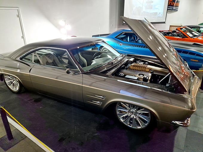 This 1965 Chevrolet Impala's hood is up, revealing the mechanical heart that powered America's love affair with the open highway.