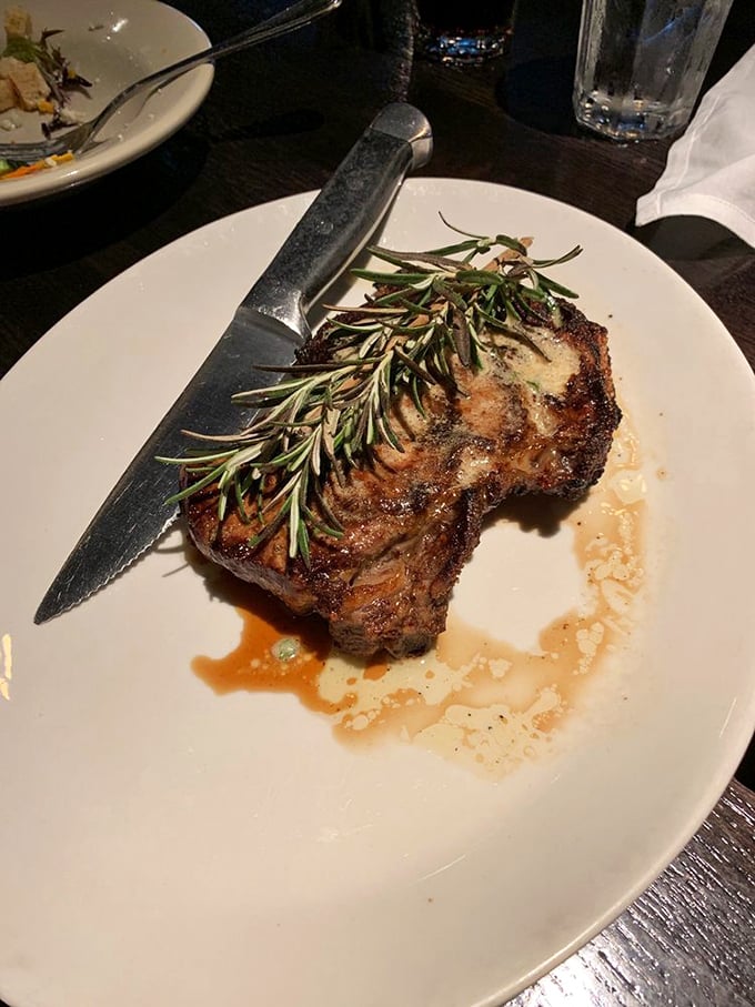 That rosemary sprig isn't just garnish&mdash;it's a victory flag planted atop a mountain of perfectly aged beef. The knife stands ready for the expedition.
