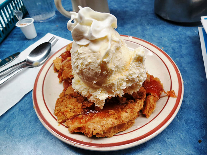 Dessert architecture at its finest&mdash;a crispy-edged apple pie crowned with ice cream melting into warm cinnamon valleys below.