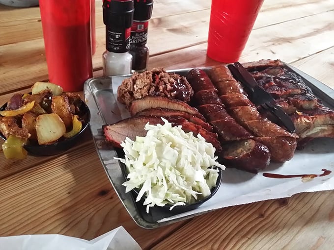 A carnivore's dream team assembled on one tray &ndash; ribs, sausage, and brisket flanked by slaw that cuts through the richness like a well-timed joke.