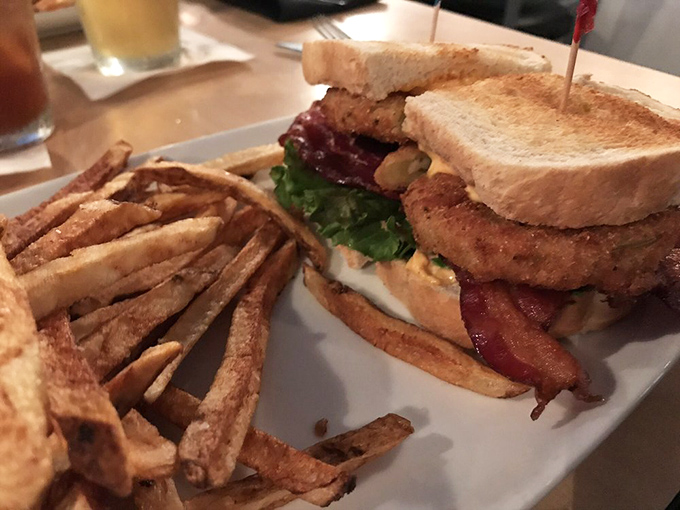 This isn't just a sandwich; it's architecture &ndash; layers of crispy bacon, garden-fresh vegetables, and golden toast forming a delicious skyscraper.