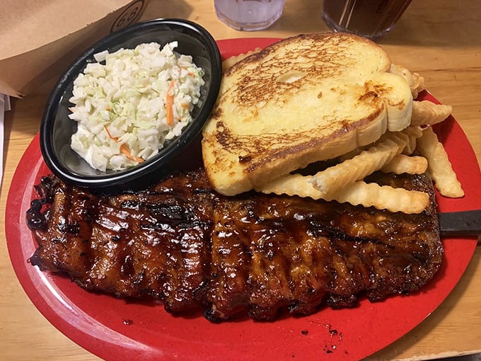 The holy trinity of Southern comfort: ribs with perfect grill marks, crispy crinkle fries, and coleslaw that knows its supporting role.