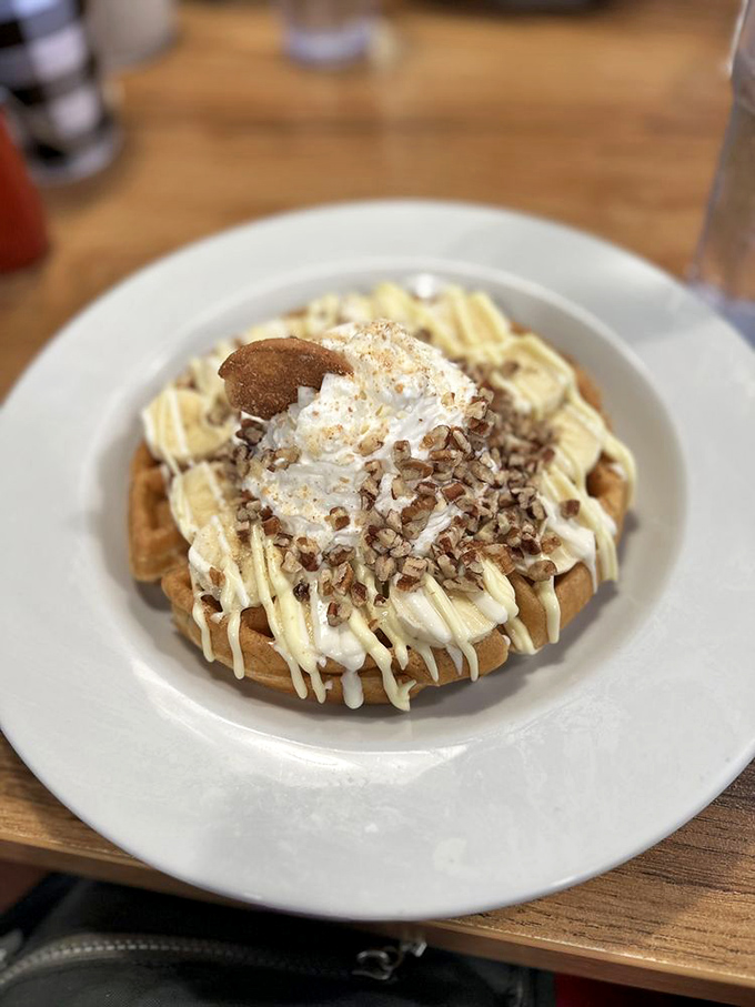 Waffle architecture at its finest! Crispy base, whipped cream summit, and a drizzle of what appears to be white chocolate and pecans. Breakfast or dessert? Yes.