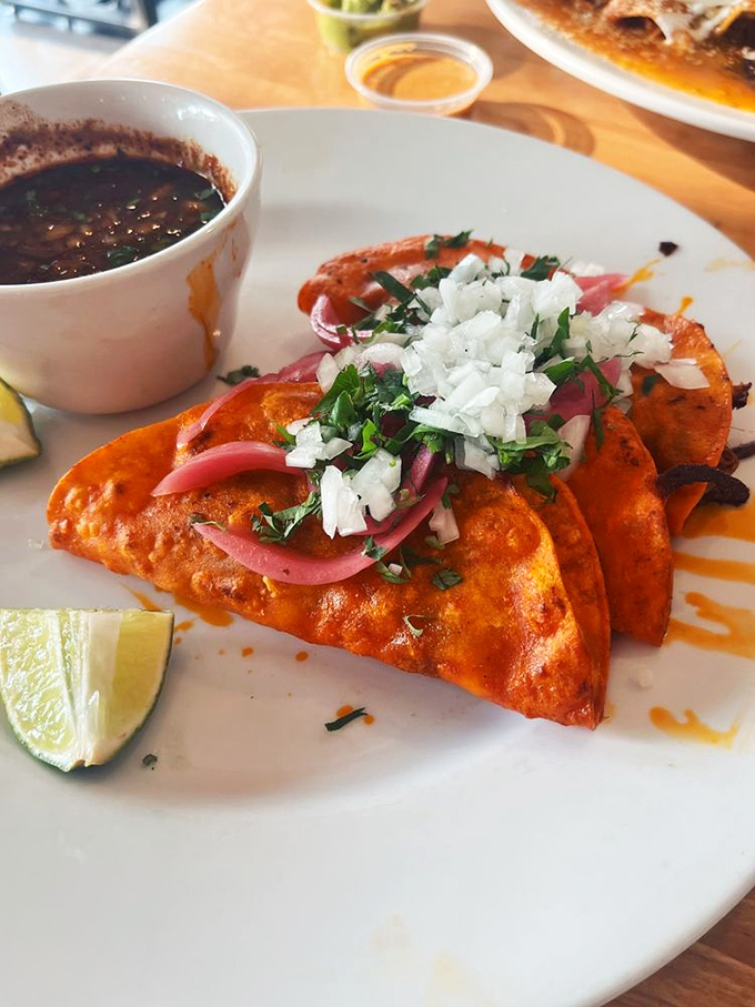 Birria tacos that demand to be photographed before eaten—though your patience will last approximately 3.7 seconds once that aroma hits.