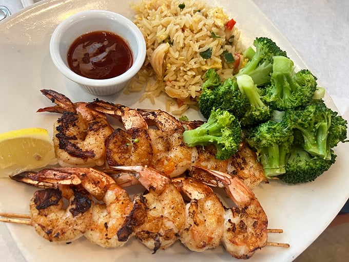 Bourbon-kissed shrimp stand at attention beside vibrant yellow rice. That perfectly charred broccoli proves vegetables can be more than an obligation.