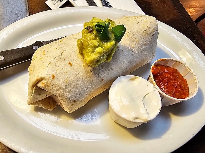 This burrito doesn't just come with sides—it comes with an entourage of sour cream and salsa ready for their supporting roles.