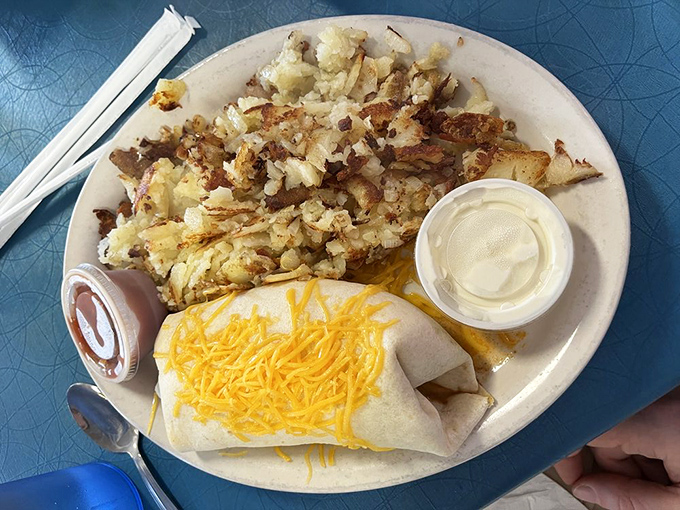Breakfast alchemy at its finest—crispy-edged hash browns beside a cheese-blanketed burrito. The morning meal of champions and hangover heroes alike.