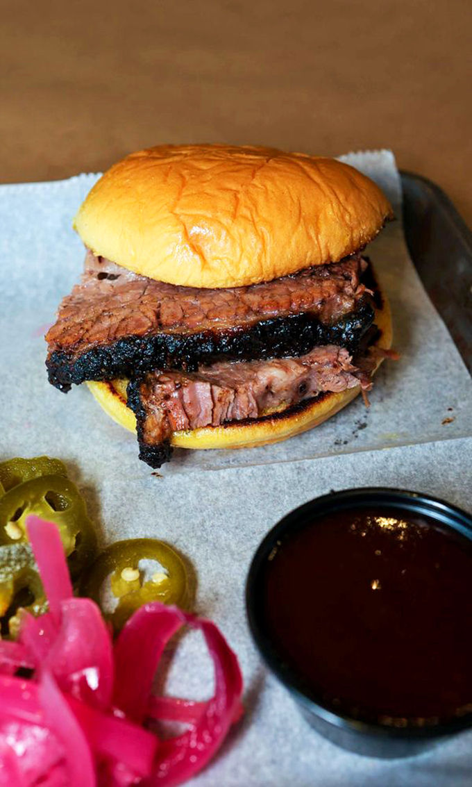 Minimalism at its meatiest: brisket on a bun with pickles waiting patiently on the sidelines&mdash;simplicity never tasted so complex.