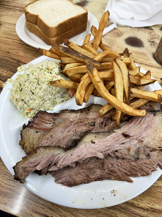Brisket so tender it practically surrenders at the sight of your fork, accompanied by golden fries and creamy coleslaw.