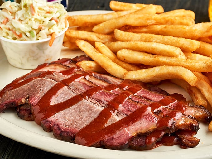 Slices of brisket arranged like meaty playing cards, each one glistening with sauce that's equal parts sweet, tangy, and "can I drink this?"