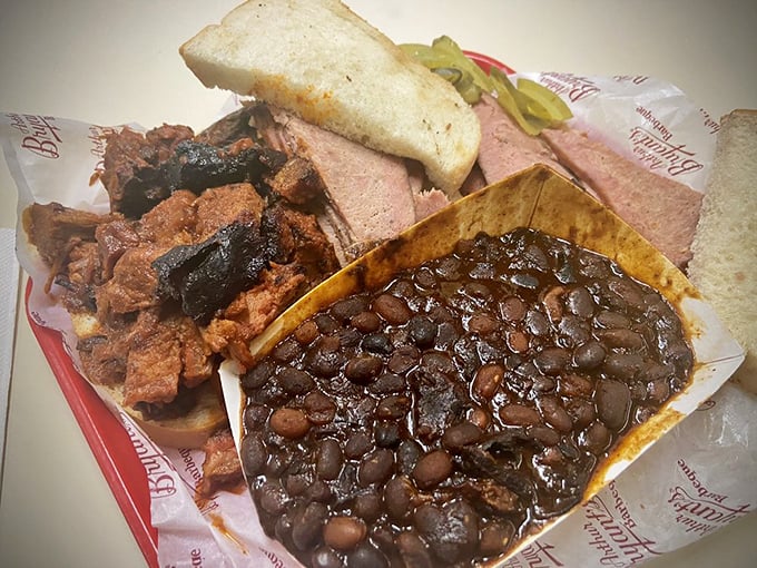 The holy trinity of barbecue perfection: burnt ends with their crispy edges, smoked sausage, and beans that have clearly been taking flavor lessons for generations.