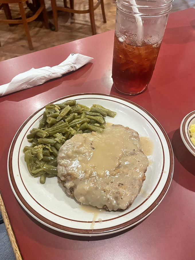 Gravity-defying gravy clinging to perfectly tenderized steak. Green beans never had a more distinguished dance partner.
