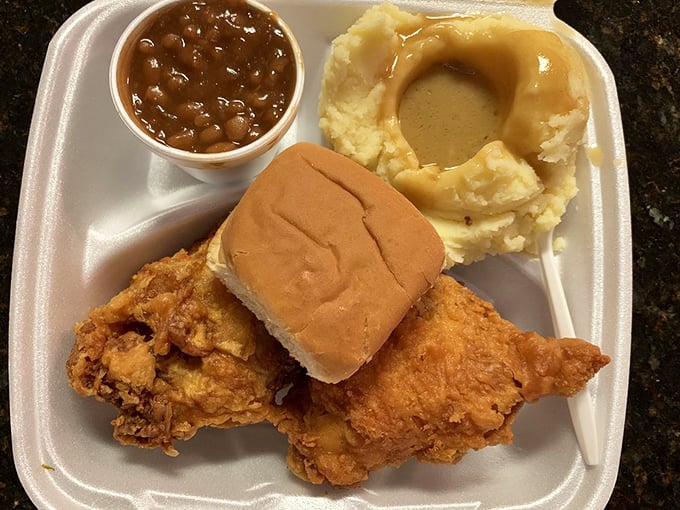 Comfort food trifecta: crispy chicken, hearty beans, and mashed potatoes with gravy deep enough to dive into.