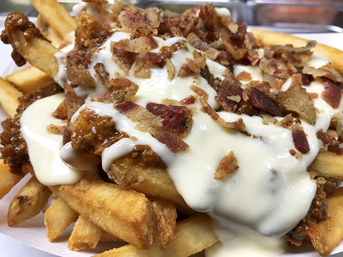Fries ascend to royalty when crowned with cheese, chili, and bacon. The fork exists merely as a suggestion here.