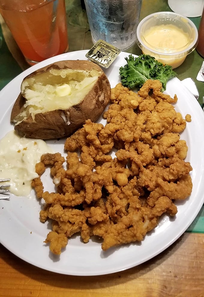 Golden-fried clam strips that shatter between your teeth, alongside a baked potato that's practically begging for a belly flop into butter.