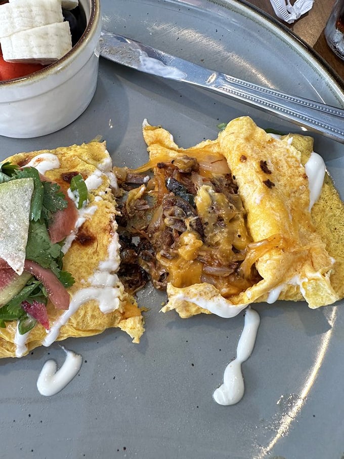 The omelet has been split open to reveal its treasure&mdash;caramelized onions and melted cheese in a fluffy egg embrace that's worth every calorie.