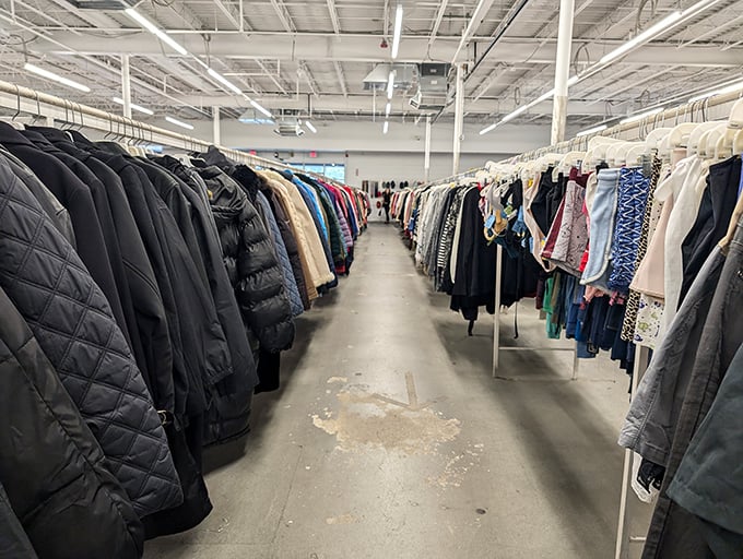 The clothing aisles stretch toward the horizon like a textile ocean. Professional wardrobe essentials mingle with weekend casual wear, all waiting for second acts.
