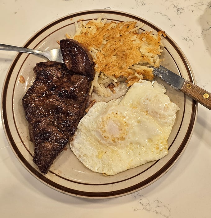 The breakfast trifecta: perfectly seared steak, eggs with sunset-yellow yolks, and hash browns crisped to golden perfection.