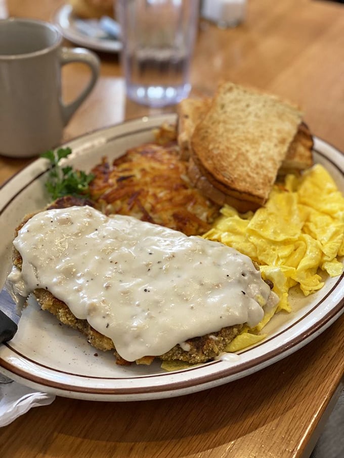 Country fried steak smothered in creamy gravy alongside golden eggs—a plate that says "nap time is imminent" but worth every drowsy moment.