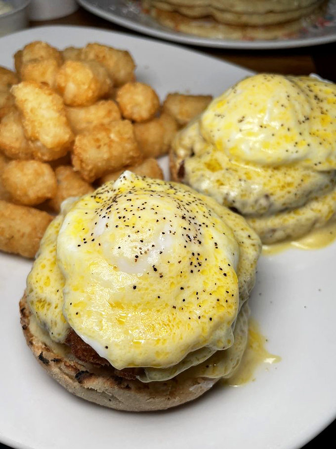 Benedict perfection: poached eggs perched atop their English muffin thrones, draped in hollandaise robes with tater tot courtiers standing by.