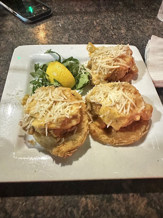 Three's company when it comes to these magnificent crab cakes. The plate arrives with a pop of color from fresh greens and a lemon wedge for brightness.
