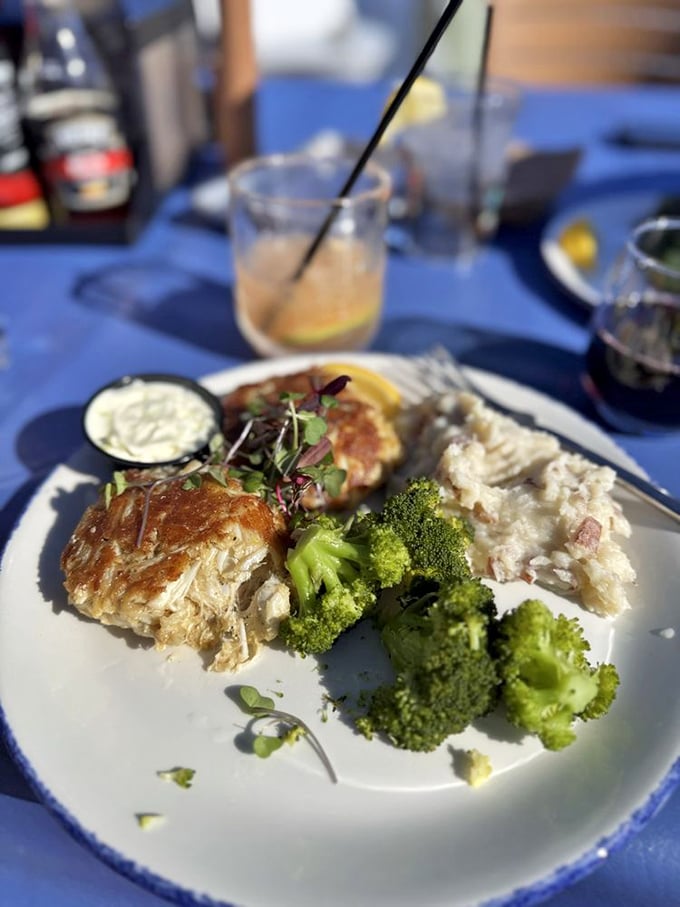 Crabcakes and broccoli bathed in golden sunlight&mdash;the kind of plate that makes you pause mid-conversation to admire before diving in.
