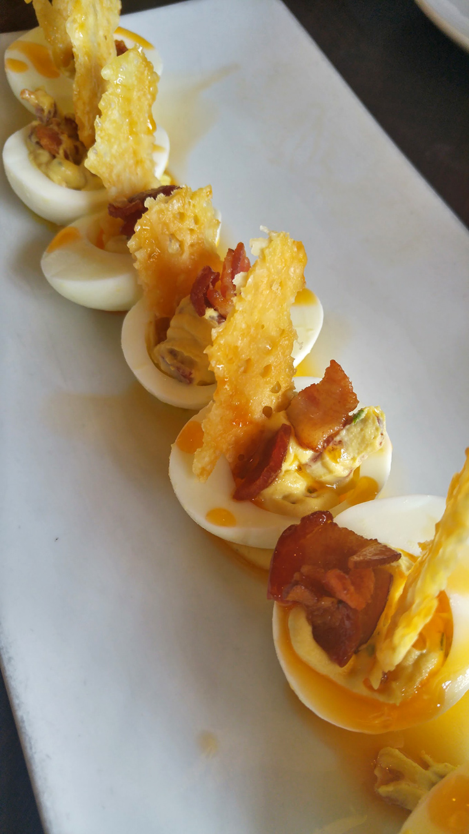 Deviled eggs topped with crispy bacon bits and fresh herbs. If eggs could dream of their afterlife, this is what they'd hope for.