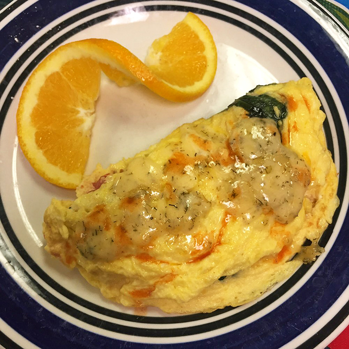 Sunshine on a plate! This omelet practically glows with cheesy perfection, while those orange slices pretend you're making healthy choices today.
