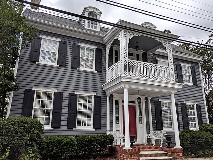 This isn't just a house&mdash;it's architectural poetry with its perfect symmetry, commanding balcony, and that red door saying "come on in."