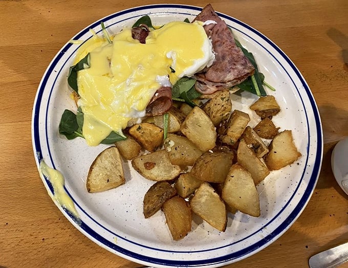 Benedict done right&mdash;where hollandaise meets ham in perfect harmony. This isn't just breakfast; it's morning symphony with potatoes as the percussion section.