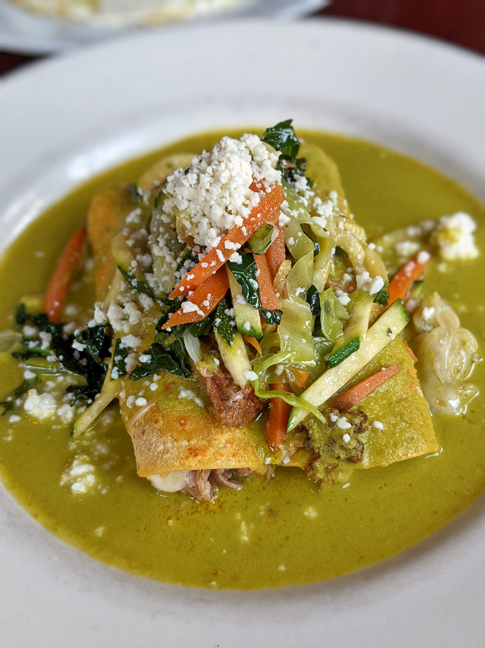 Enchiladas bathed in verde sauce that's the color of spring itself. The julienned vegetables add crunch, color, and the satisfying feeling that you're eating something virtuous and decadent simultaneously.
