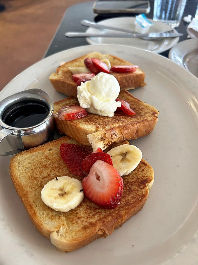 French toast that's dressed for success with fresh fruit and a dollop of cream. The maple syrup waits patiently for its grand entrance.