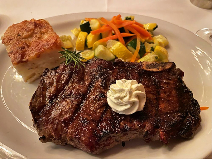 The steak arrives with perfect grill marks that would make a geometry teacher proud, topped with a butter crown worthy of beef royalty.