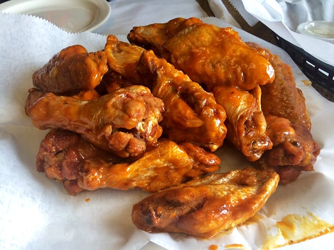 Buffalo wings glowing with that signature orange sauce &ndash; the kind that demands extra napkins and leaves your fingers deliciously stained with no regrets.