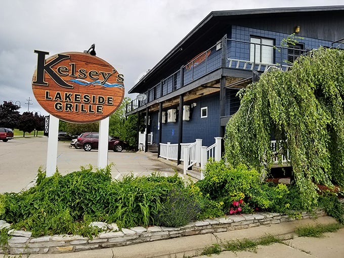 Kelsey's Lakeside Grille stands ready for hungry travelers, its navy exterior and wooden sign promising comfort food with a side of water views.