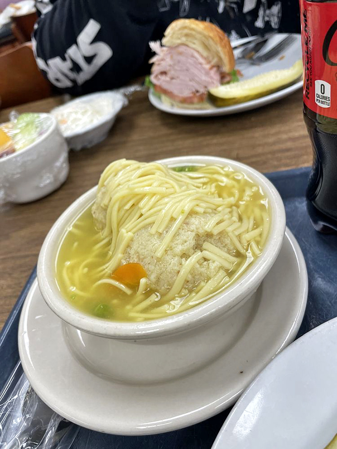 The matzo ball soup&mdash;where a fluffy dumpling island floats in golden broth, offering comfort that transcends cultural boundaries.