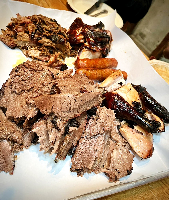 The carnivore's dream platter: a United Nations of meat where brisket, ribs, and sausage negotiate deliciously on butcher paper.