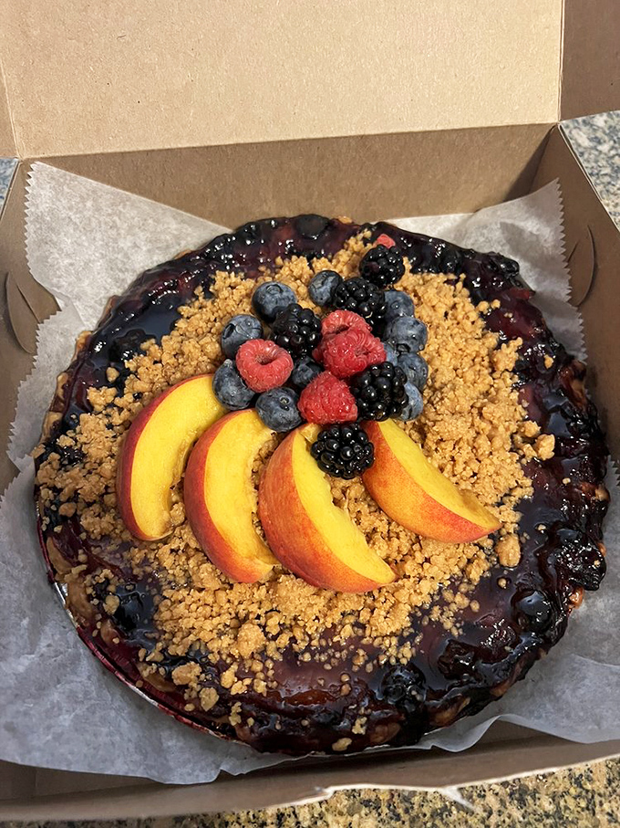 A mixed berry masterpiece topped with fresh peach slices and berries. It's like summer decided to throw a party and everyone was invited.