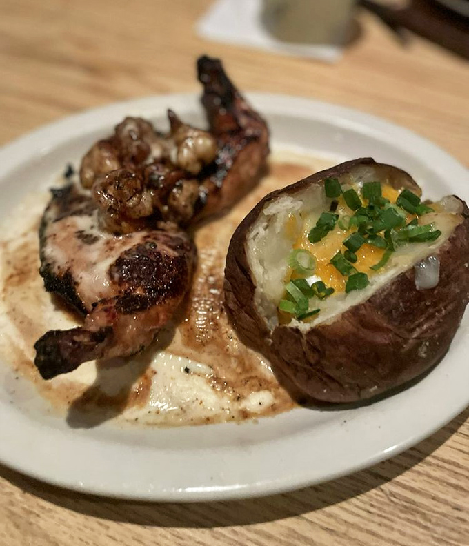 A perfectly charred chicken breast meets its match with a fully-loaded baked potato that's dressed better than most people at formal events.